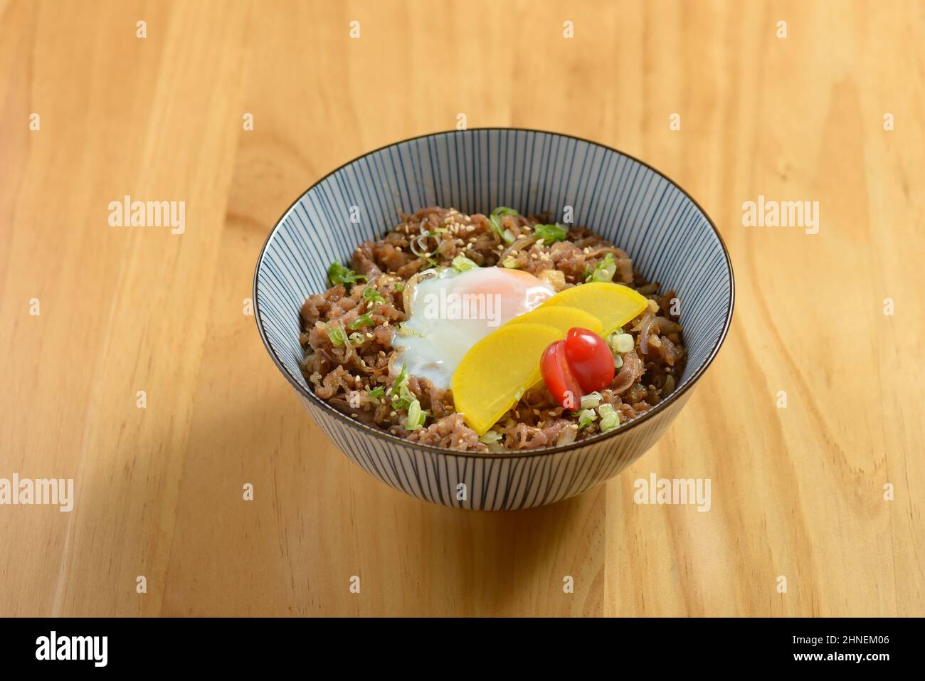 Tasty beef Gyudon with fried rice, egg and onion in a bowl on wooden ...