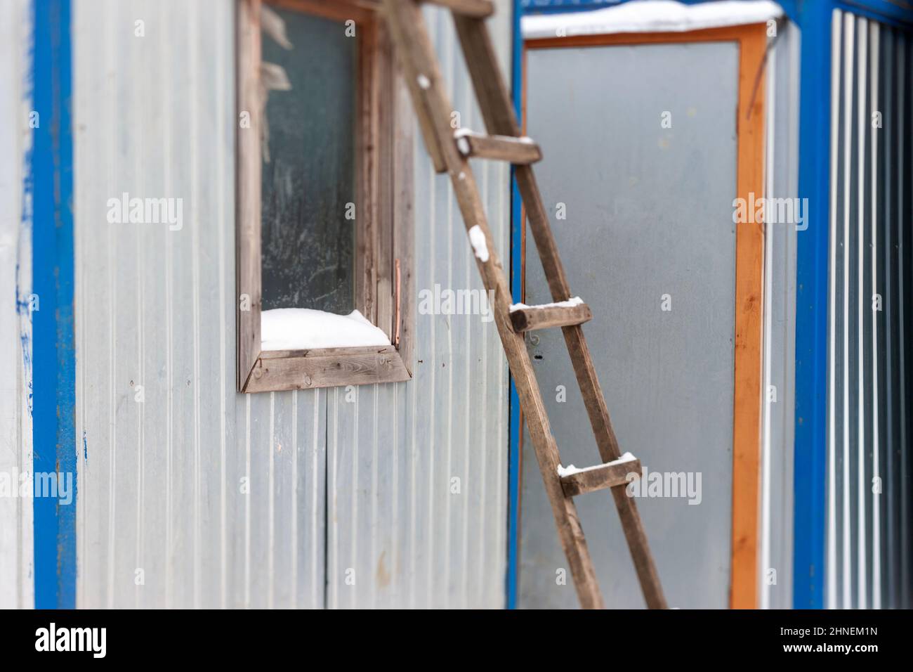 a ladder leaning against a metal container, outdoor shallow DOF image ...