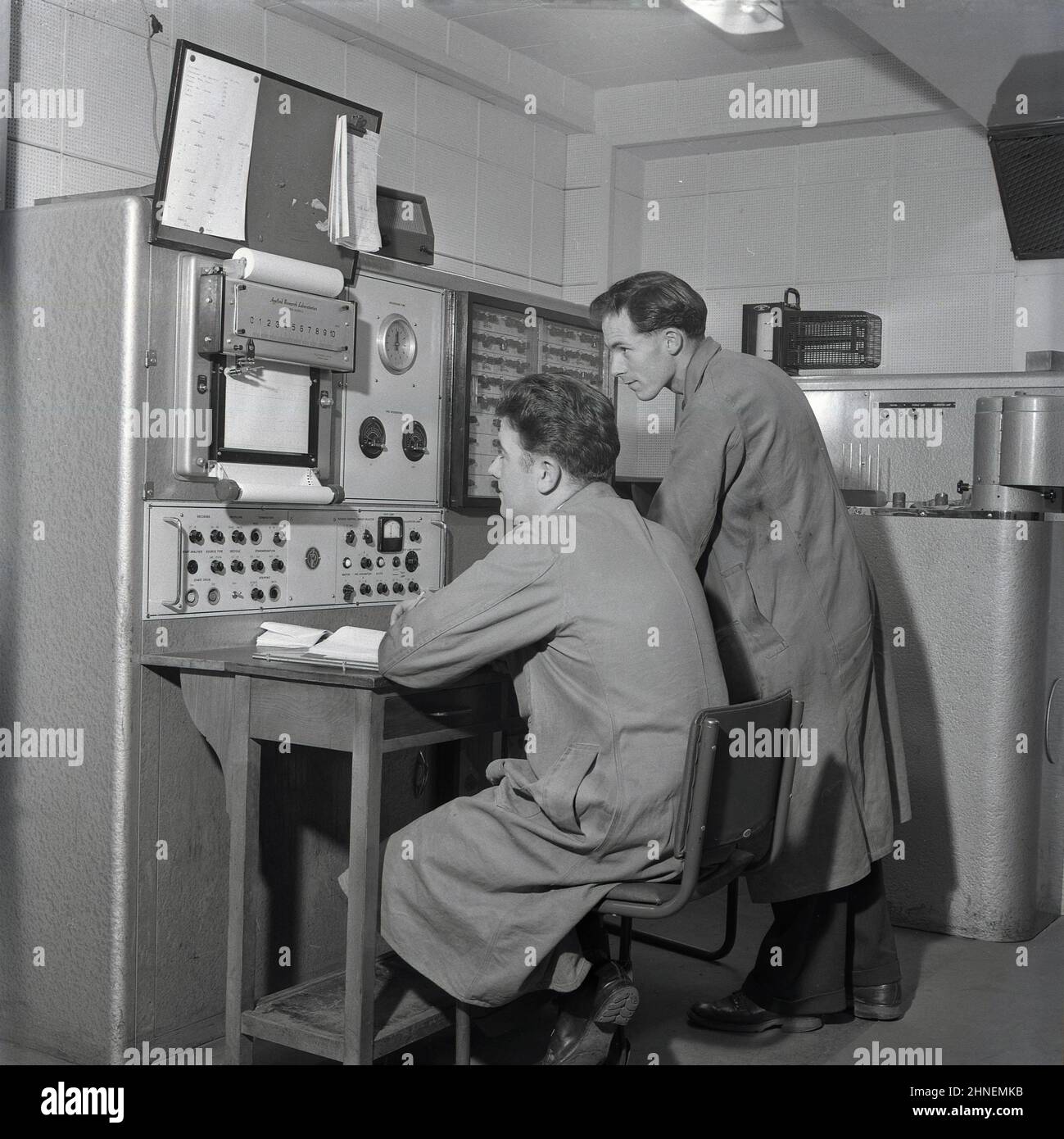 1950s, historical, two male technical staff in long work coats at the ...