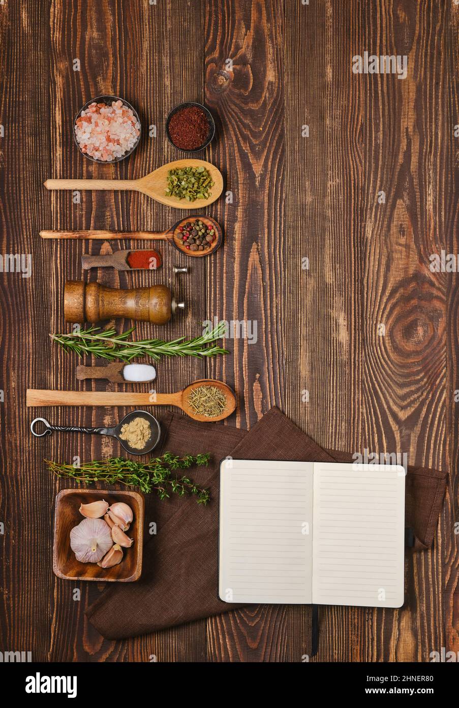 Top view of open notepad for recipes next to kitchen spoons and bowls ...