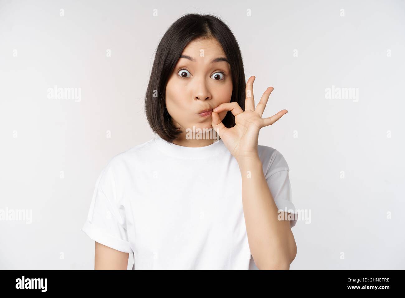 Image of young asian woman showing silence gesture, zipping mouth, seal ...
