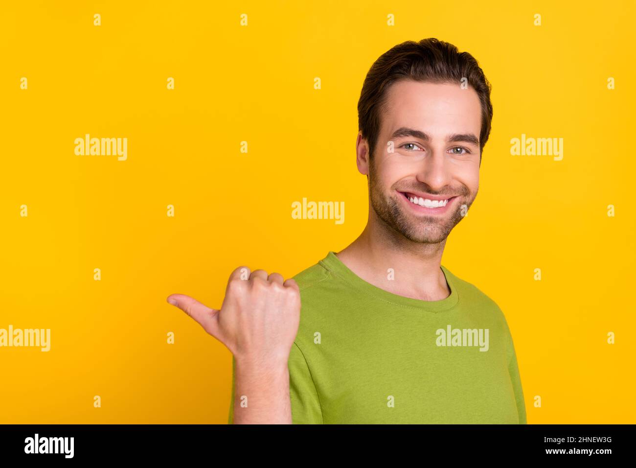 Profile side photo of young cheerful man promoter indicate finger empty ...