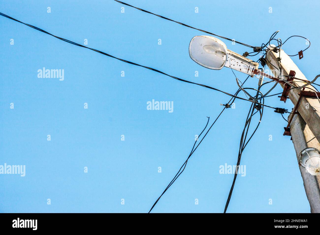 a damaged electric wire on a light pole needs to get fixed, low angle ...