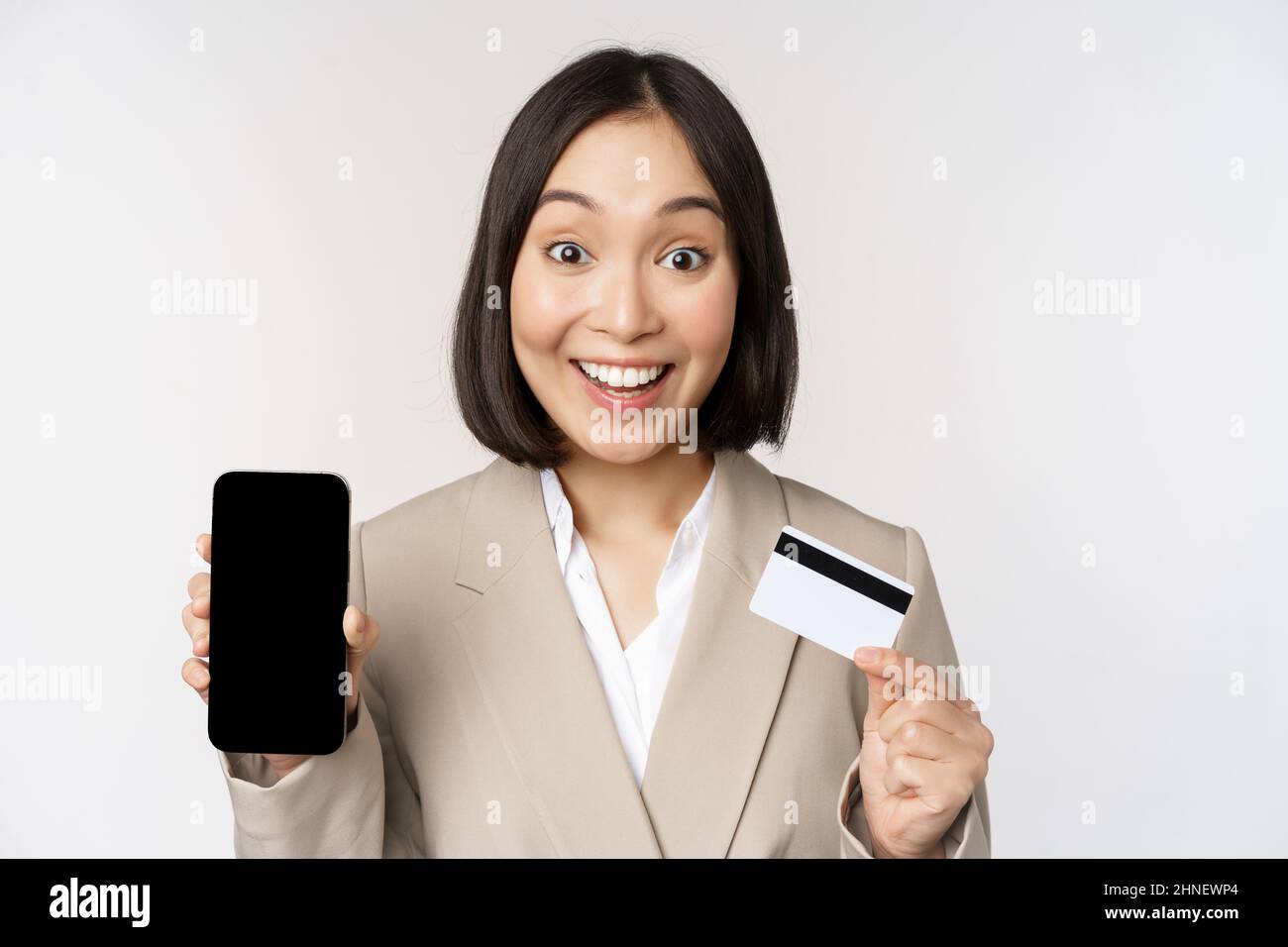 Corporate woman with happy, enthusiastic face, showing credit card and ...