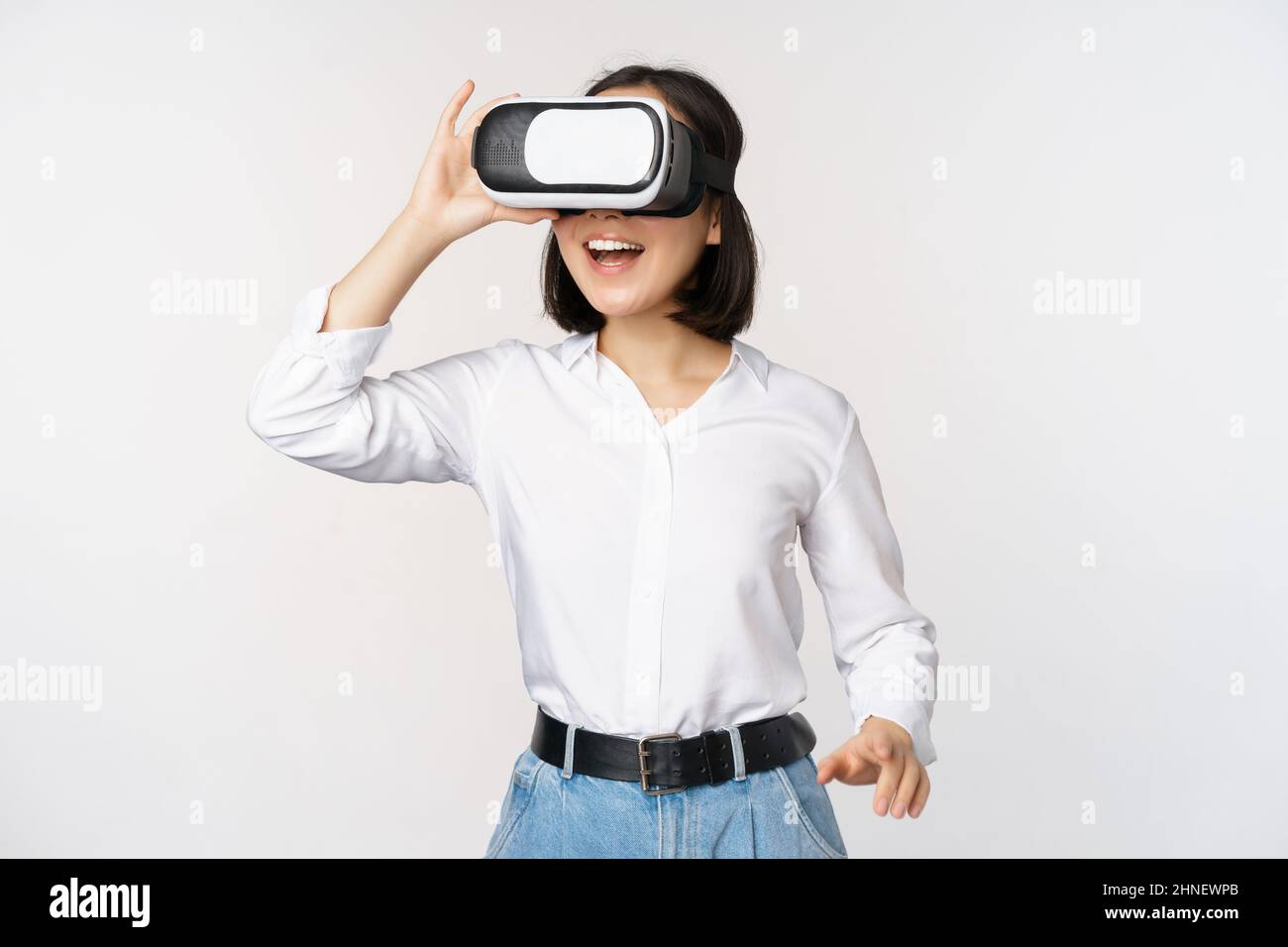 Excited young woman enter virtual reality in her glasses. Asian girl ...