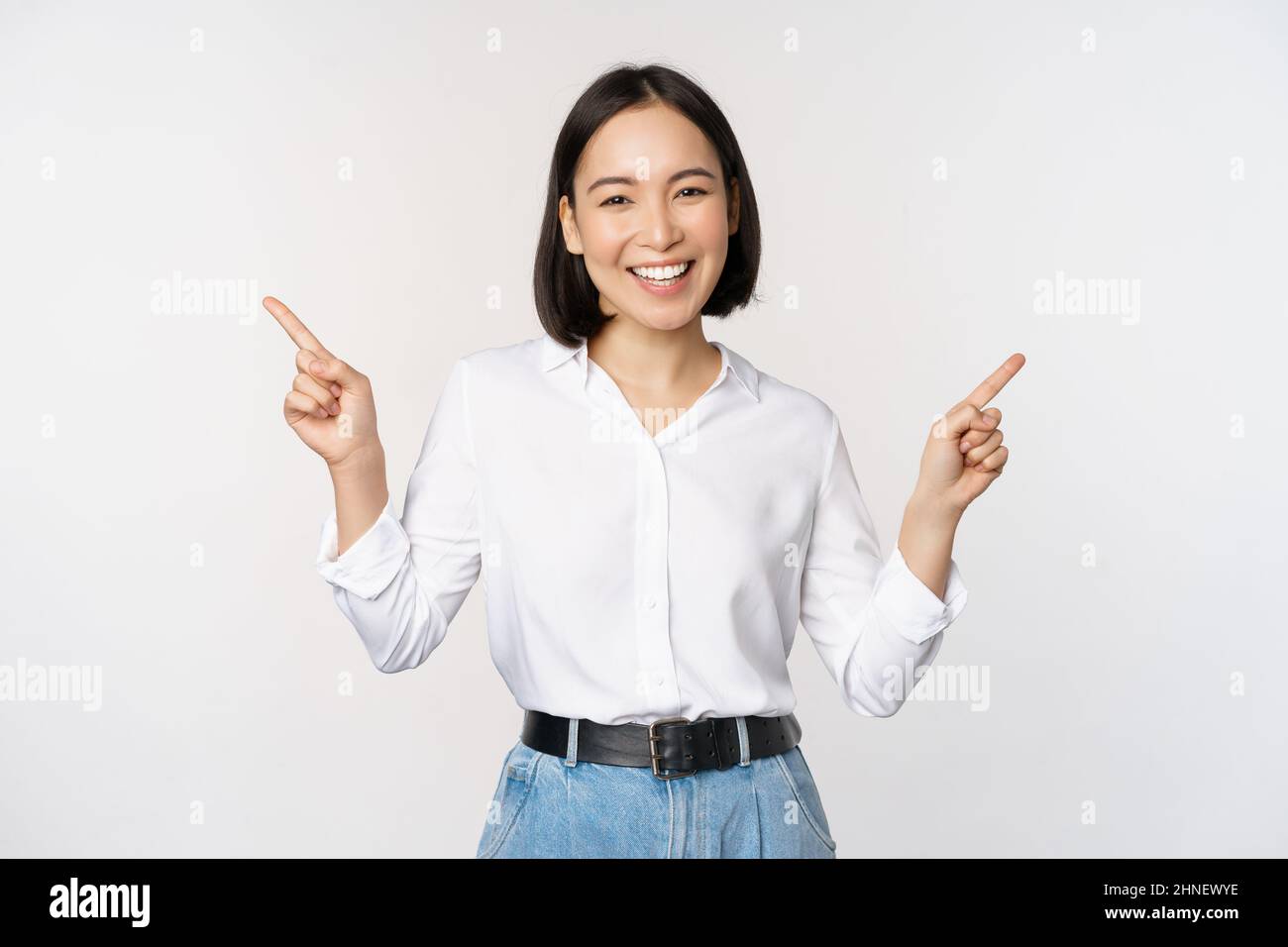 Image of beautiful asian woman pointing fingers left and right, making ...