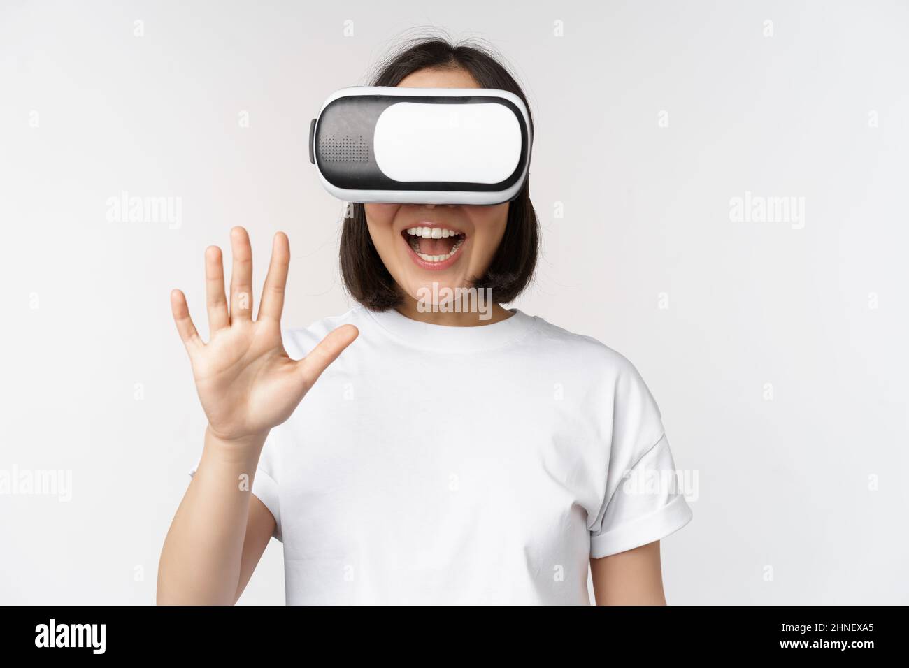Happy asian woman using VR headset, waving raised hands and laughing ...