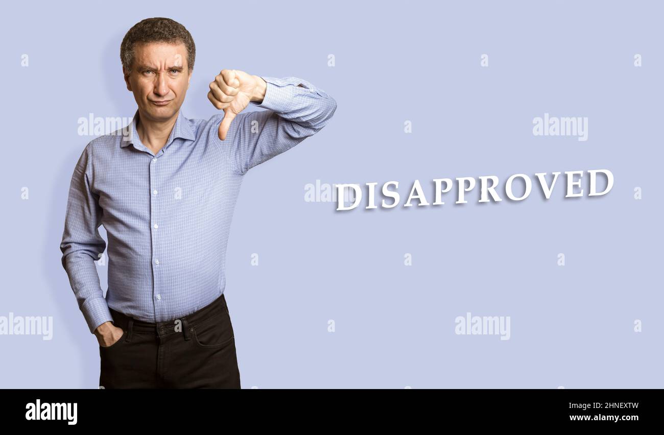 Frowning man showing negative feedback disapproval dislike sign Stock ...