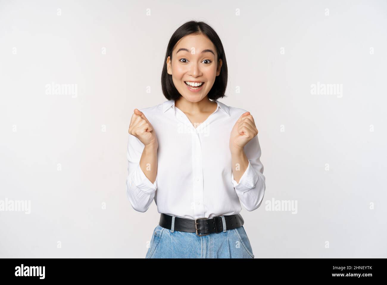 Enthusiastic asian woman rejoicing, say yes, looking happy and ...