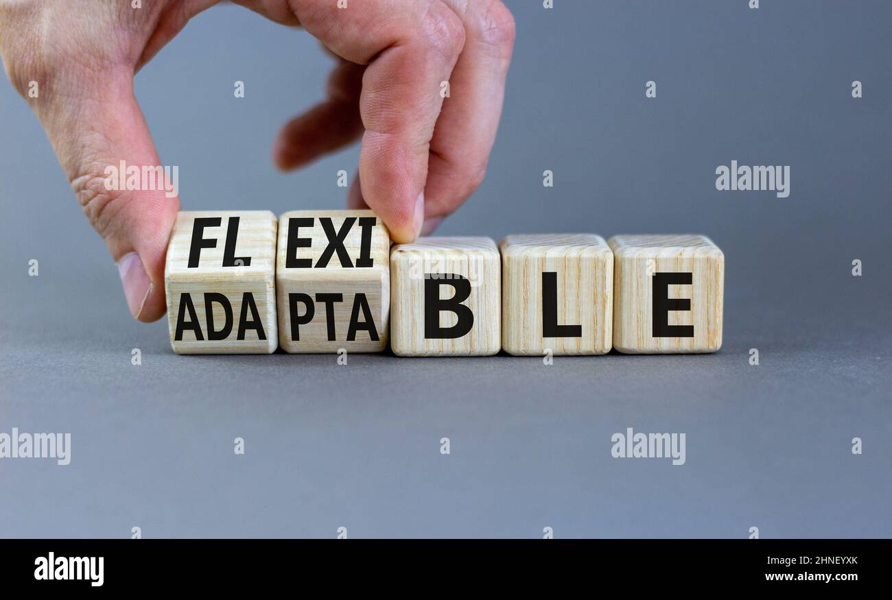 Adaptable or flexible symbol. Businessman turns wooden cubes and ...