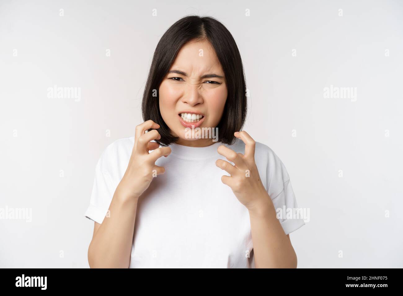 Angry asian woman cursing, looking outraged and annoyed, clench teeth ...