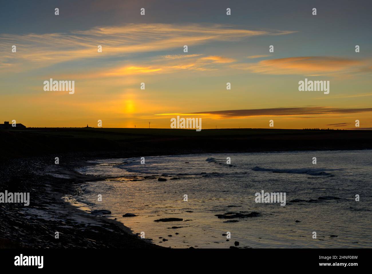 Sunset with a sun pillar, also called a solar pillar, from the beach ...
