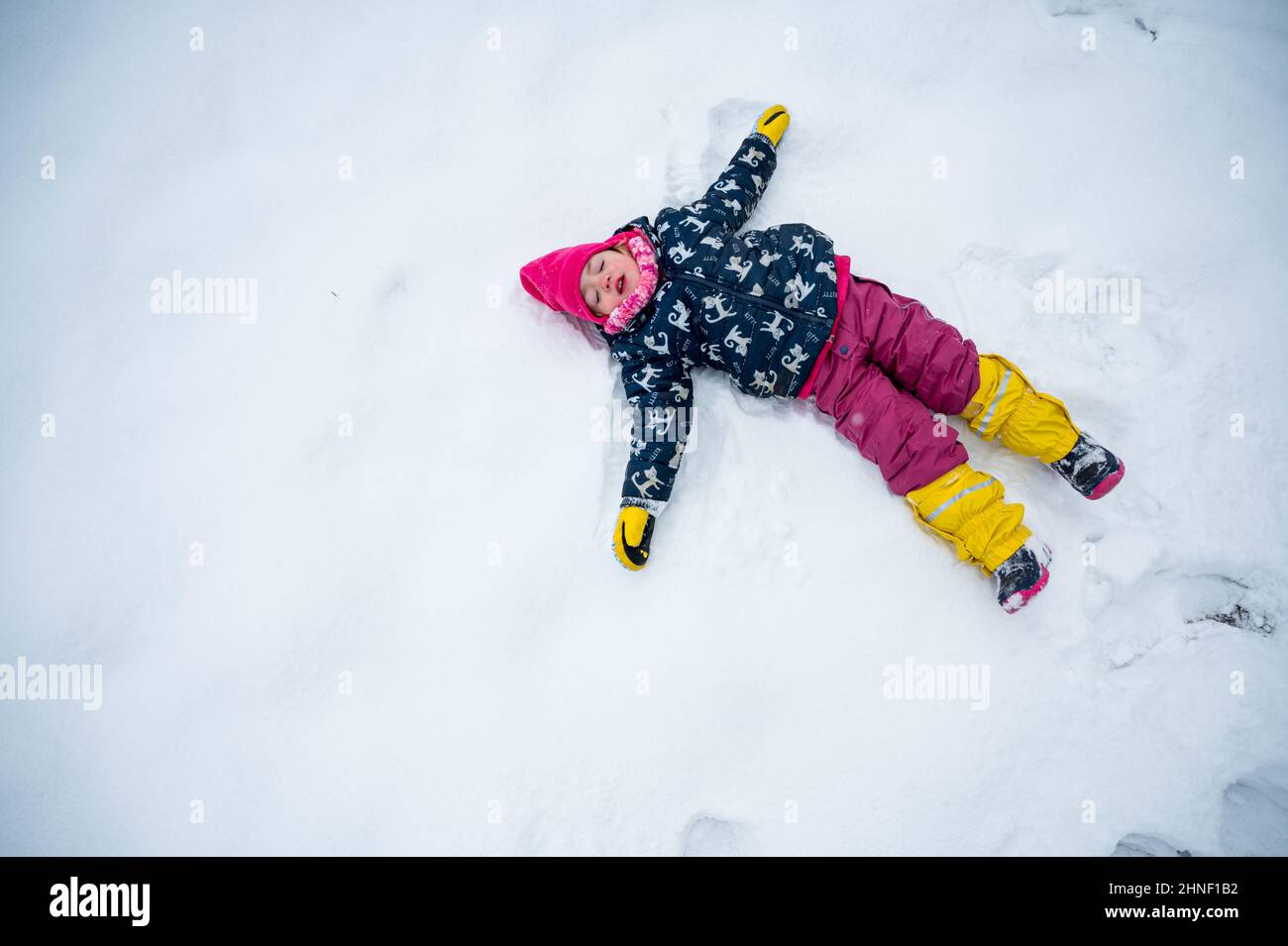 Happy girl making snow angel hi-res stock photography and images - Alamy