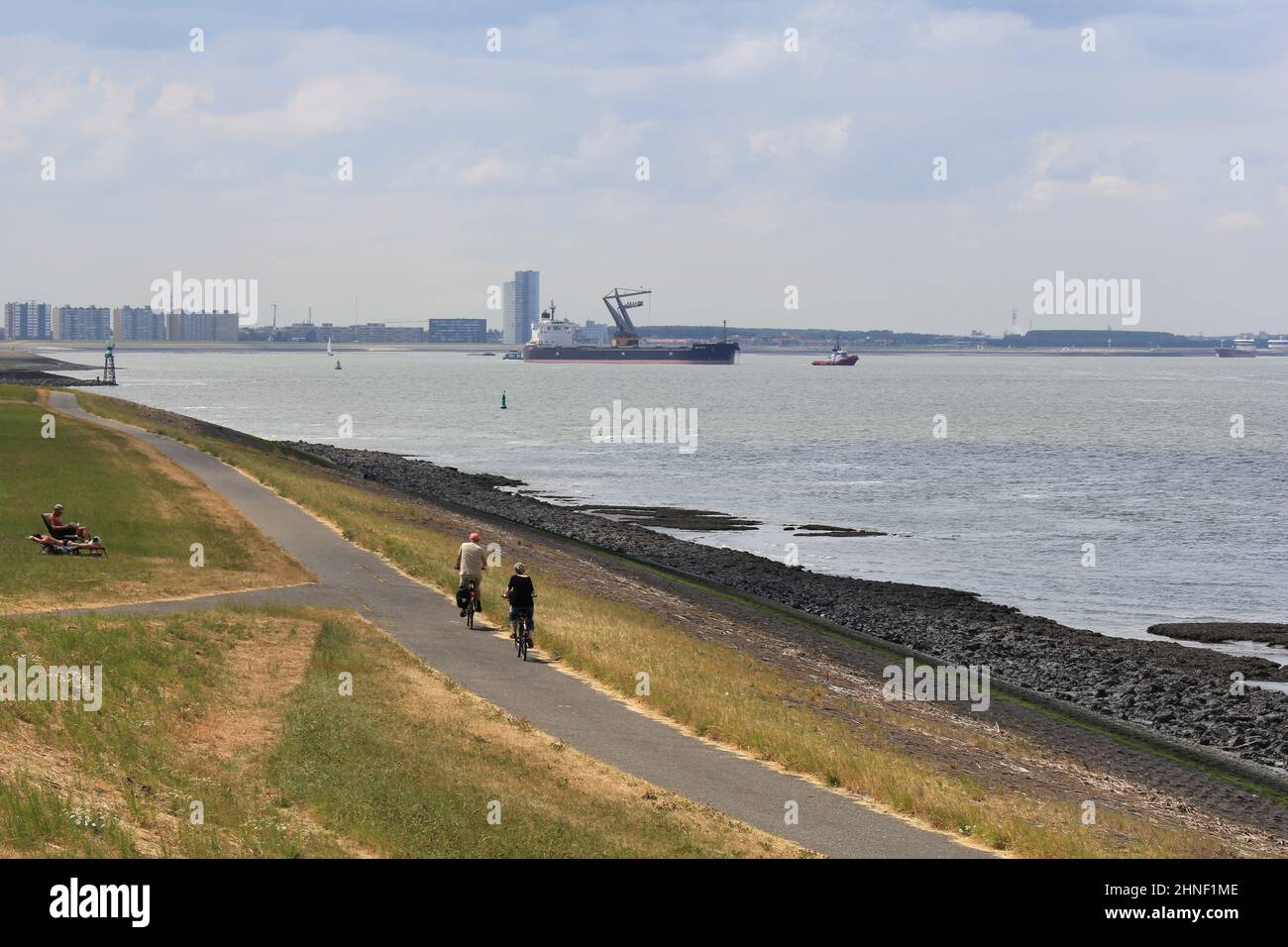 view at the skyline, seawall with cyclists and water of the ...