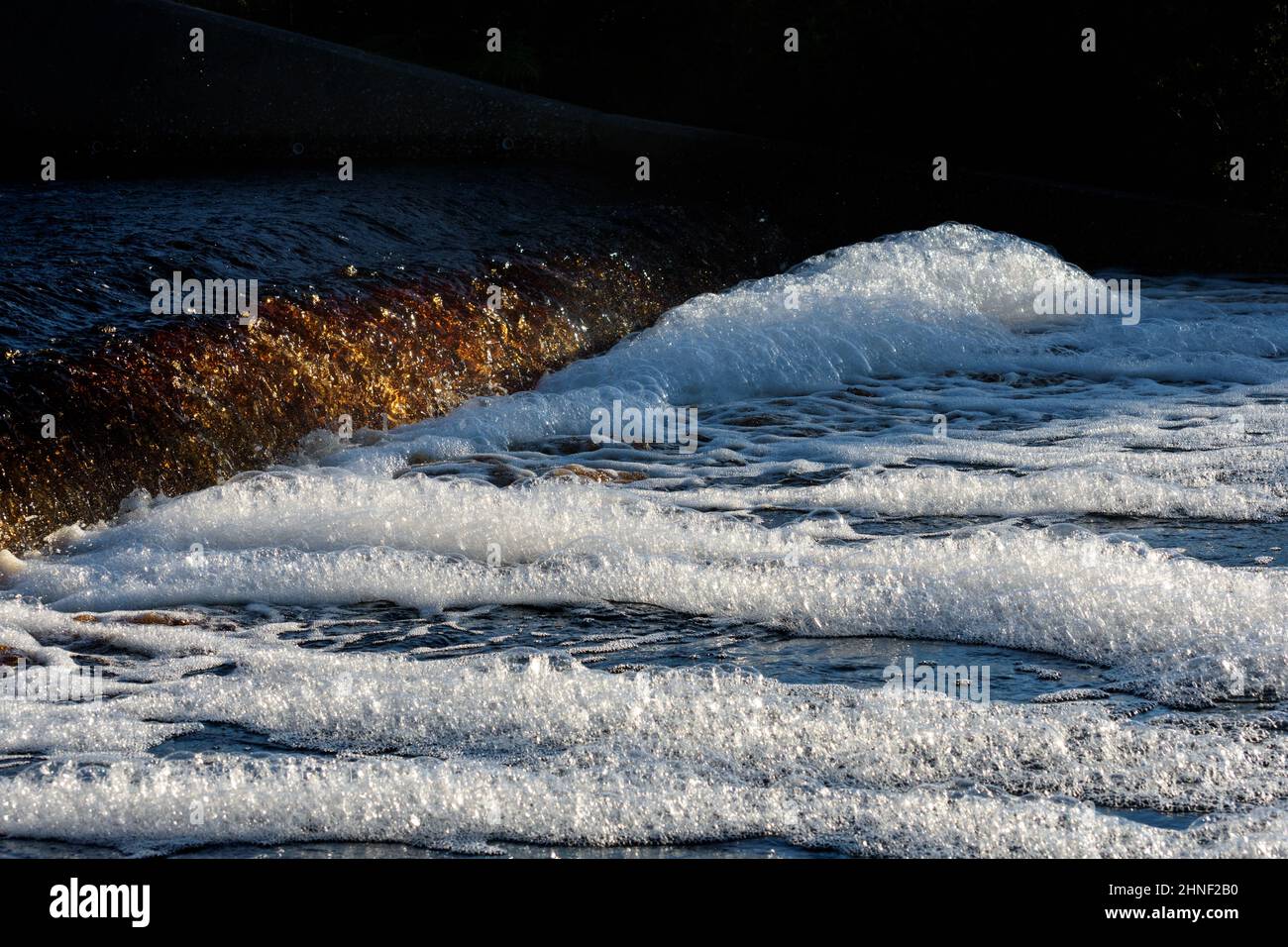 Foam in a rushing river Stock Photo - Alamy