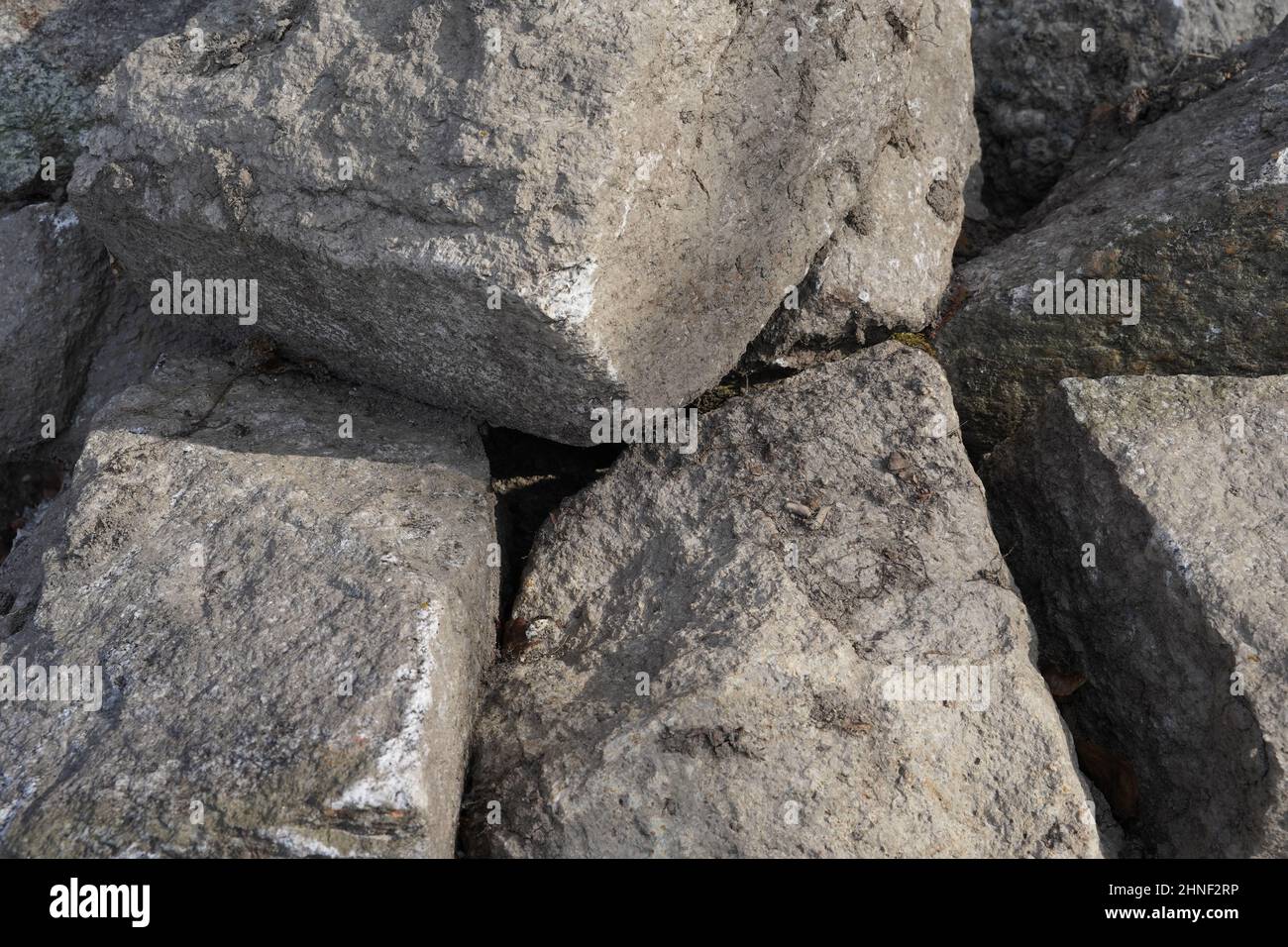 Stone cubes close up. They are randomly spread on the ground ...