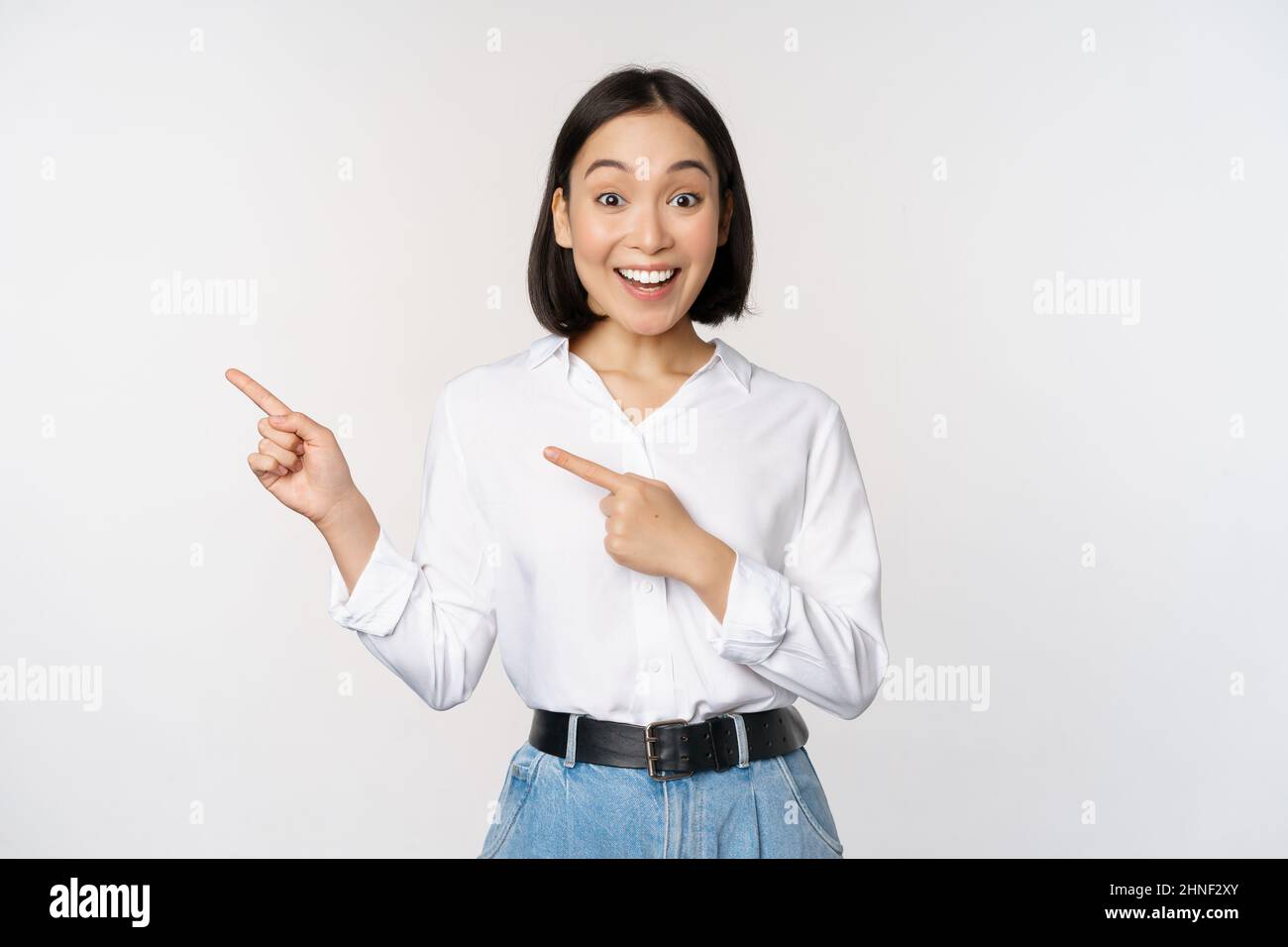 Portrait of excited young asian woman, office lady pointing fingers ...