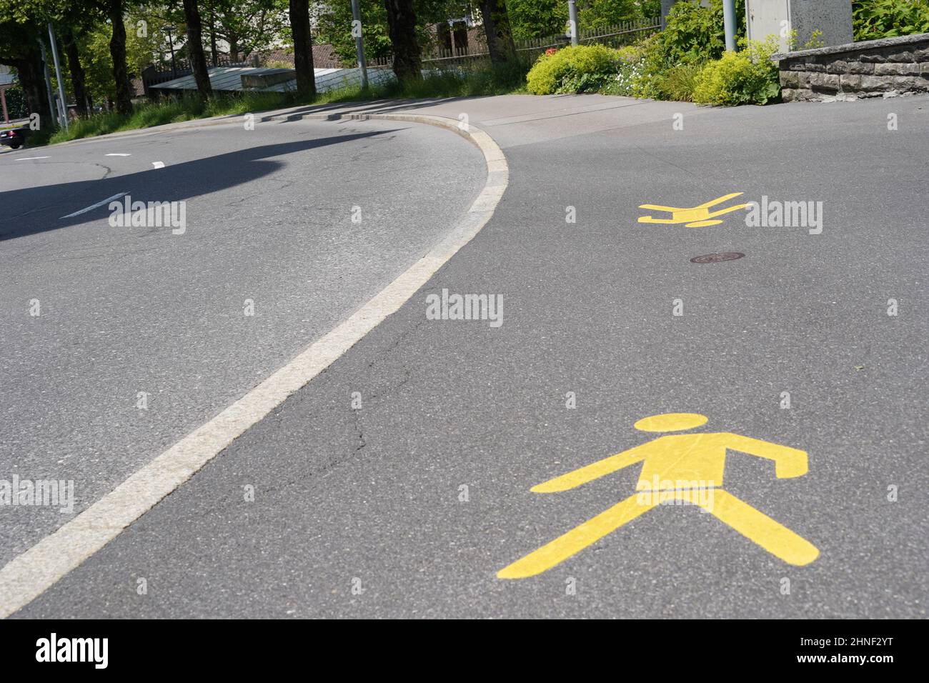 Sidewalk with pictures of pedestrian in yellow color Stock Photo - Alamy