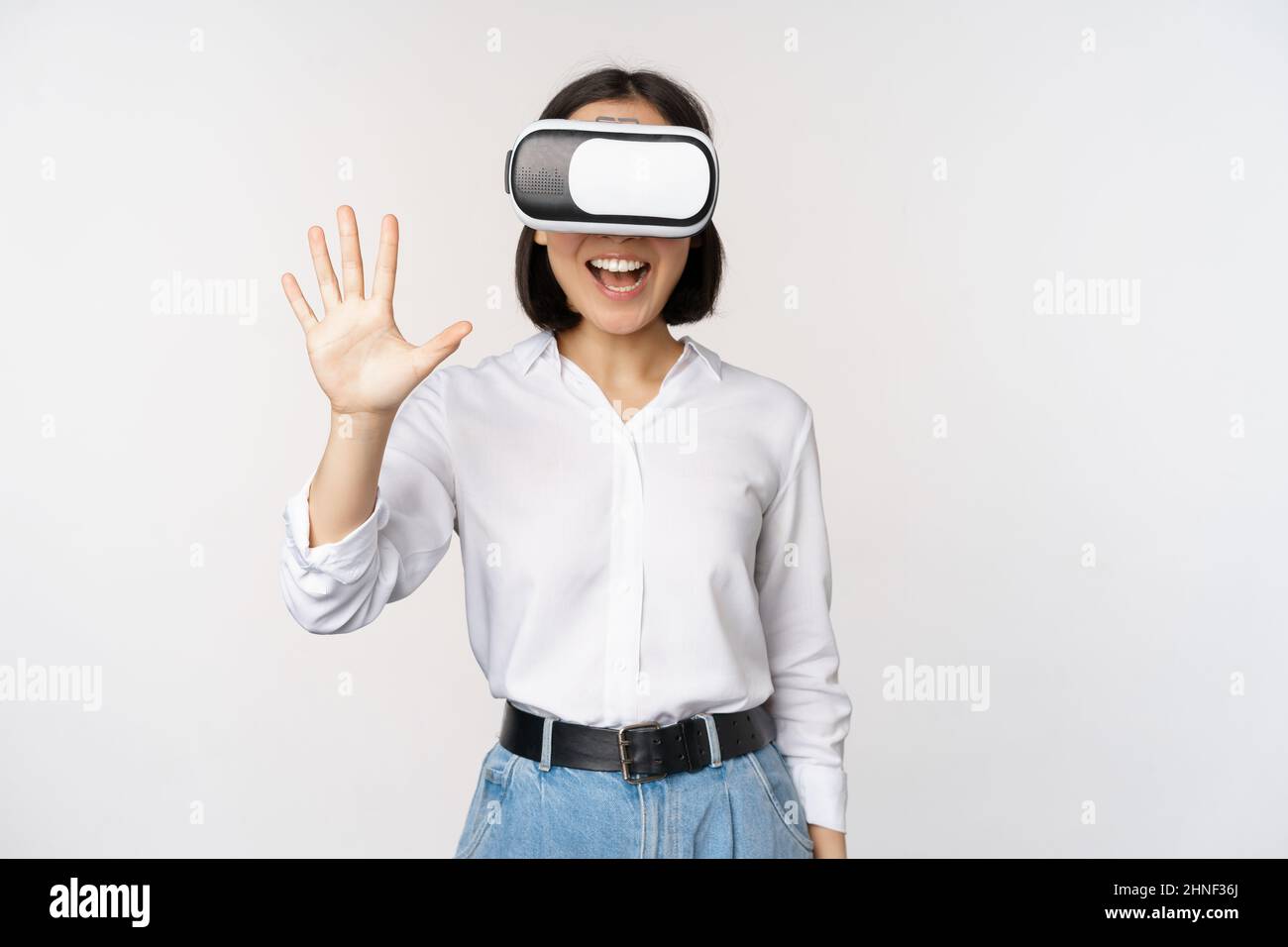 Smiling asian woman waving at you, wearing virtual reality glasses, vr ...