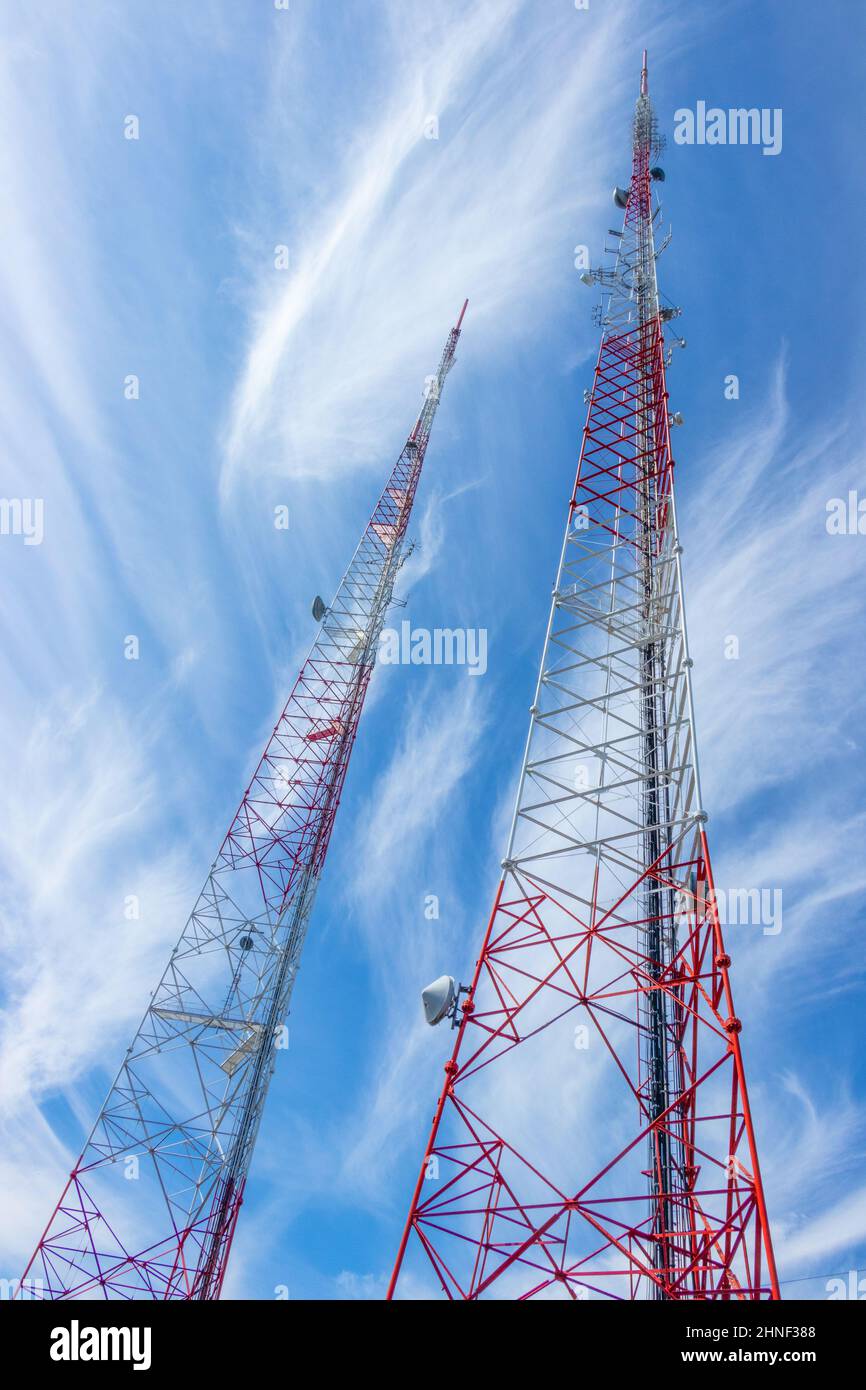 red and white broadcast towers or pylons of radio and tv stations in ...