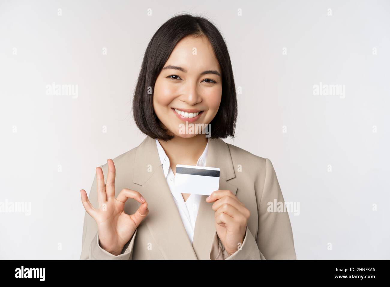Smiling office clerk, asian corporate woman showing credit card and ...