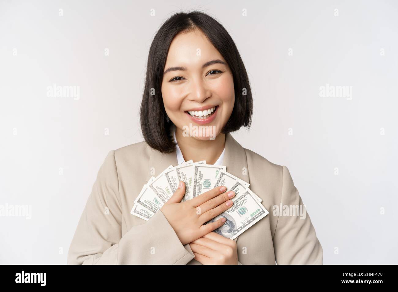 Happy asian businesswoman holding cash, hugging dollars money and ...