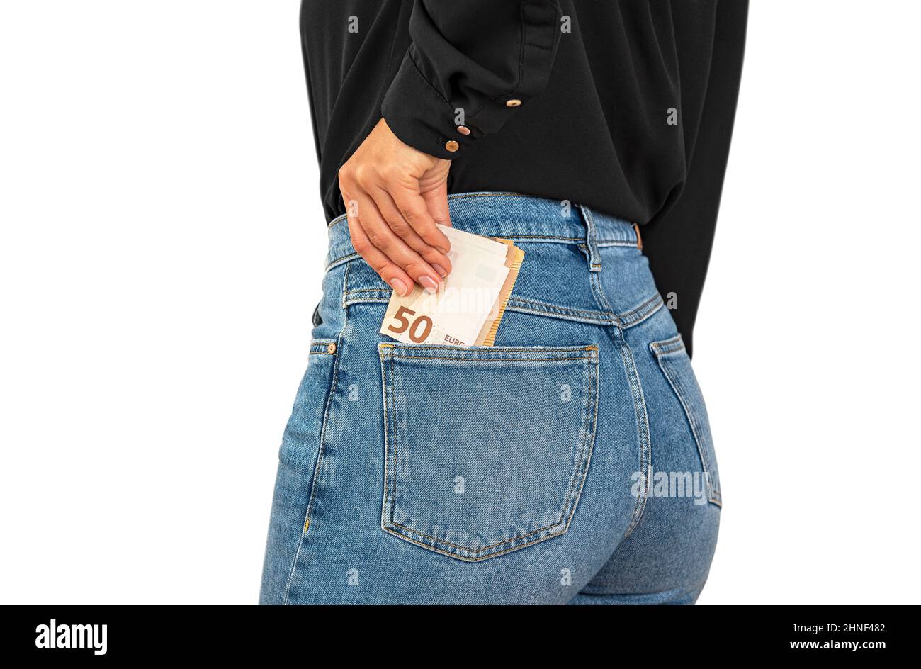 Woman with her hand putting 50 euro bills in her back pocket of jeans ...