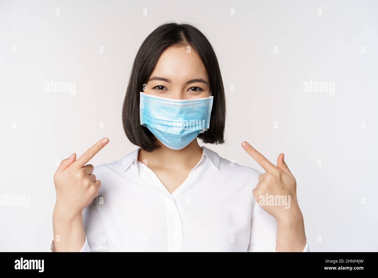 Image of young asian woman pointing at herself while wearing medical ...