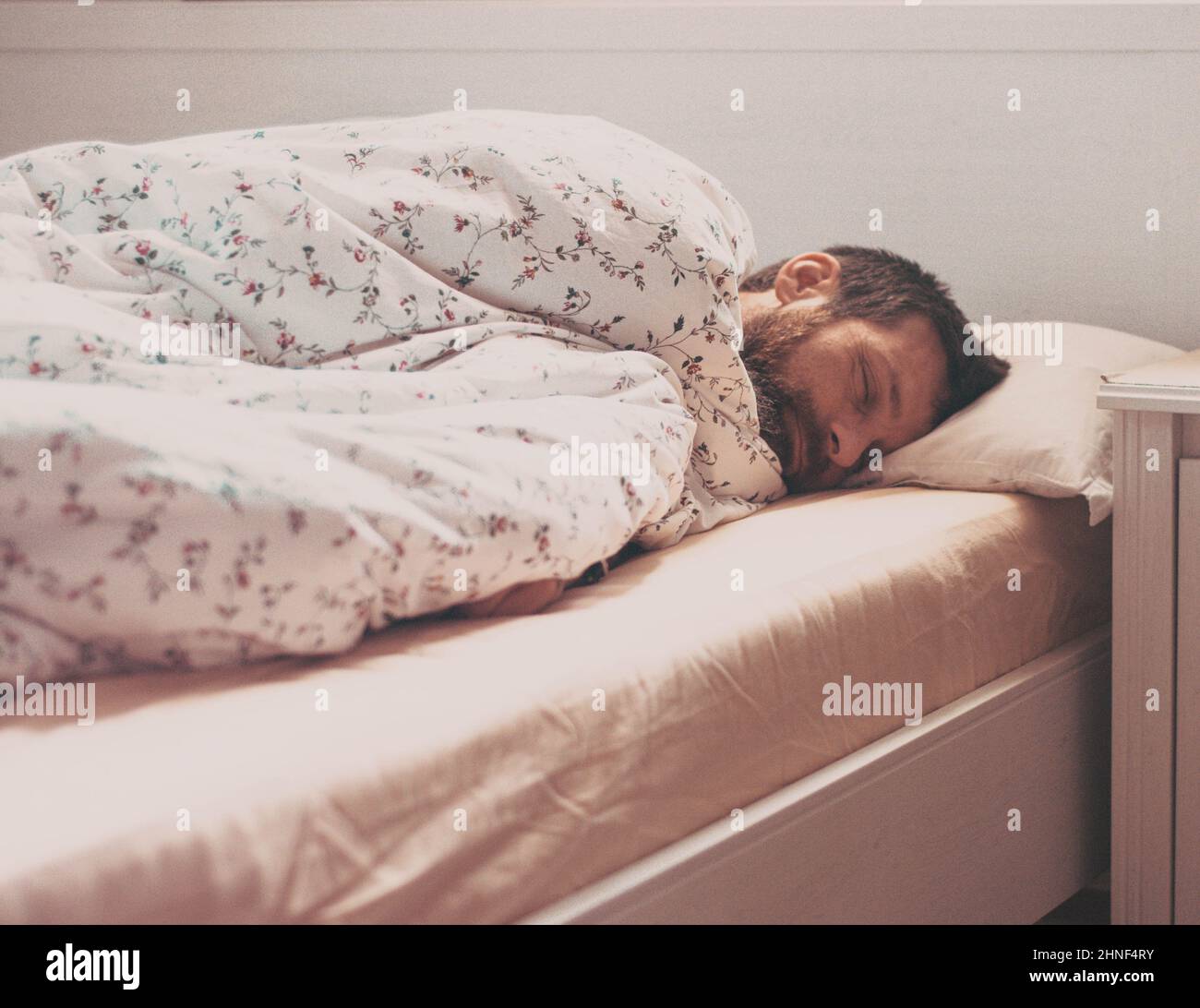 Carefree man sleeping on his side in bed in morning. dream concept ...