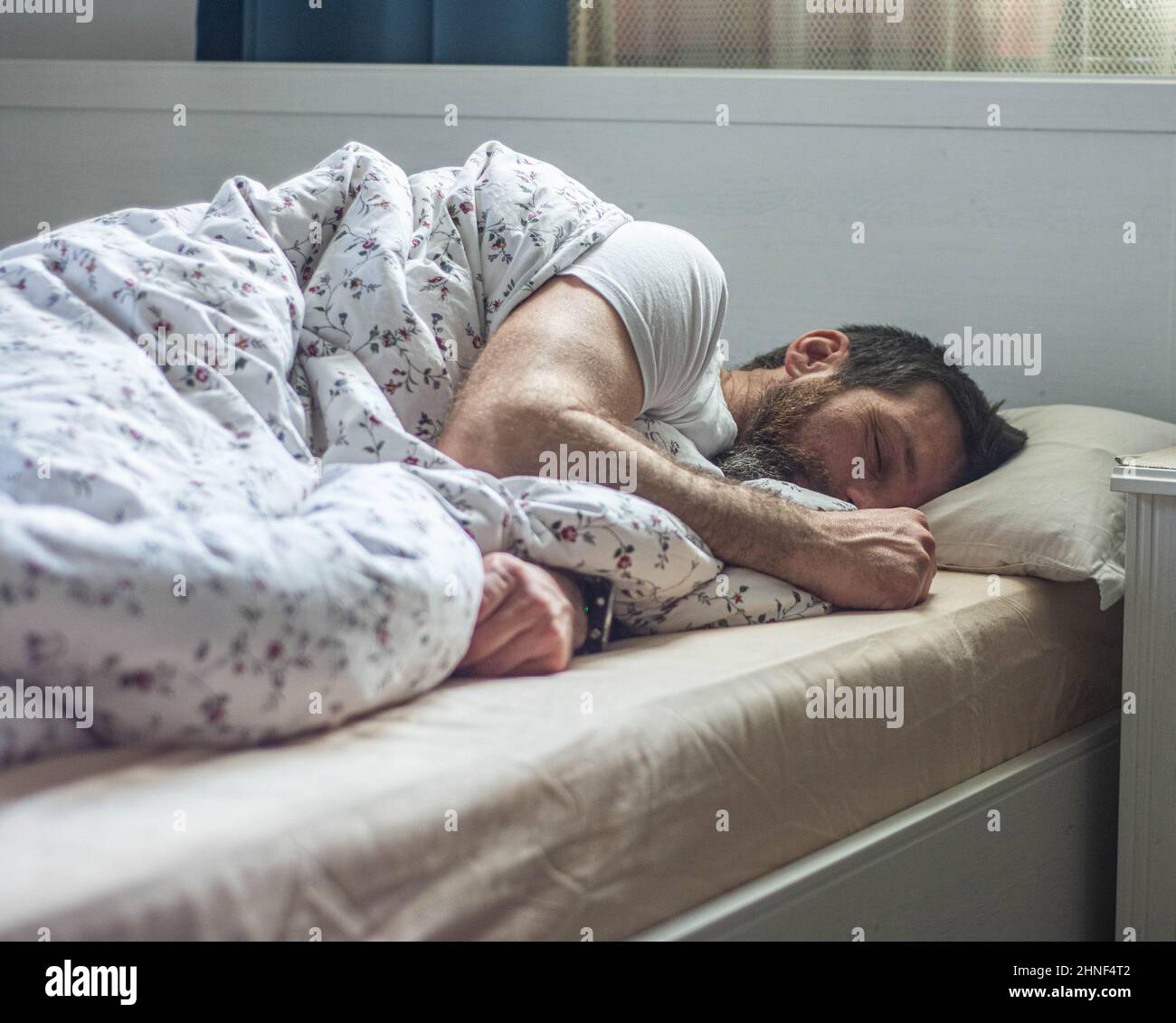 Carefree man sleeping on his side in bed in morning. dream concept ...