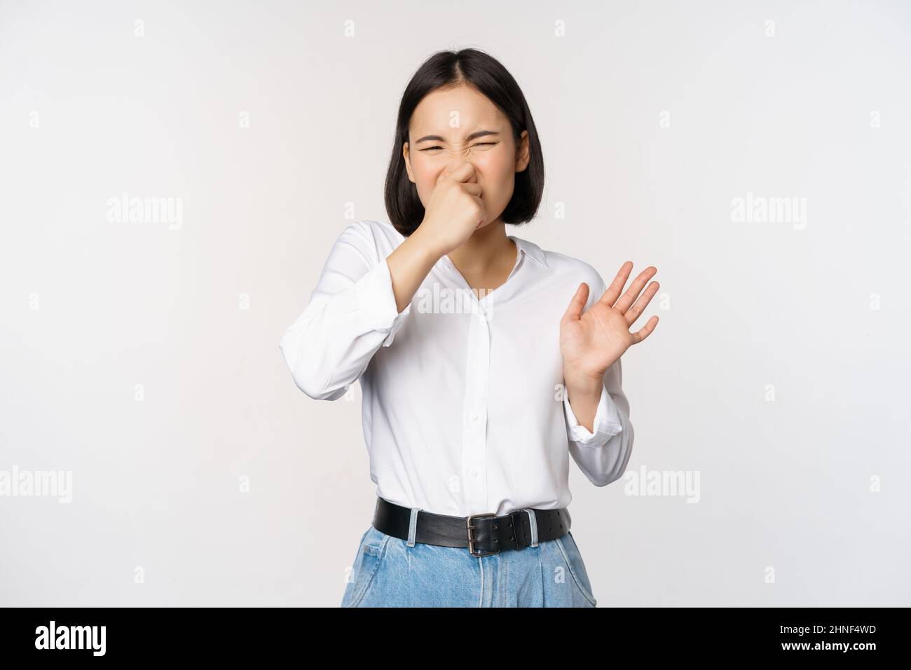 Disgusted asian girl close nose and showing rejection gesture ...