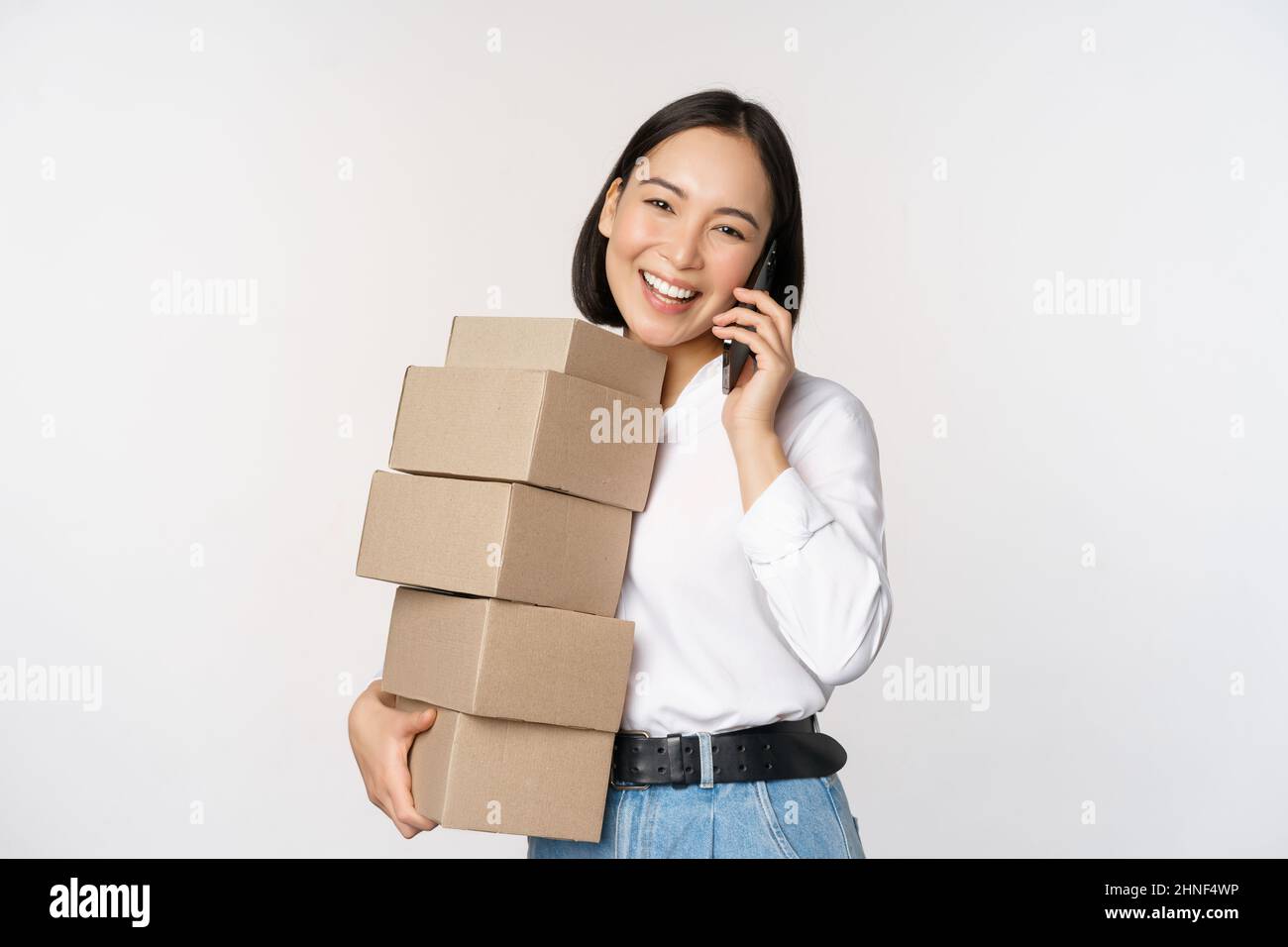 Image of young asian businesswoman answer phone call while carrying ...