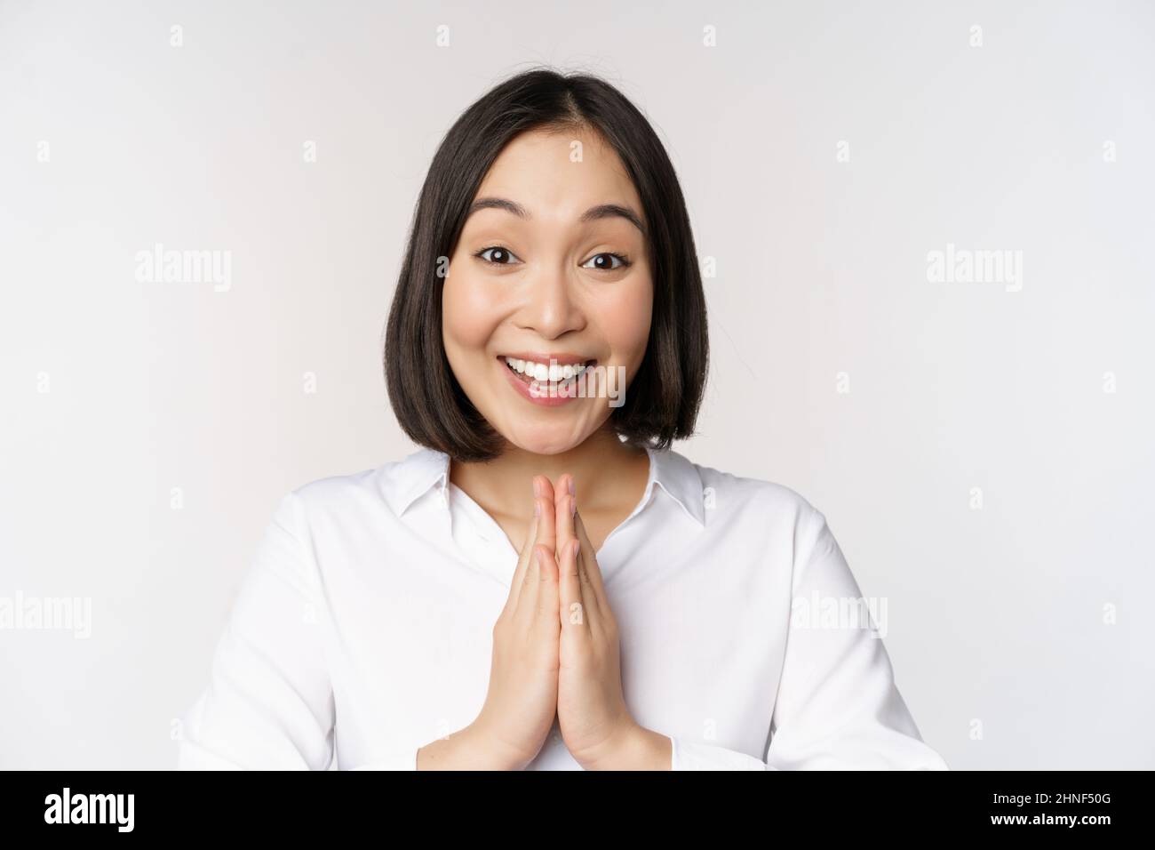 Close up portrait of young japanese woman showing namaste, thank you ...