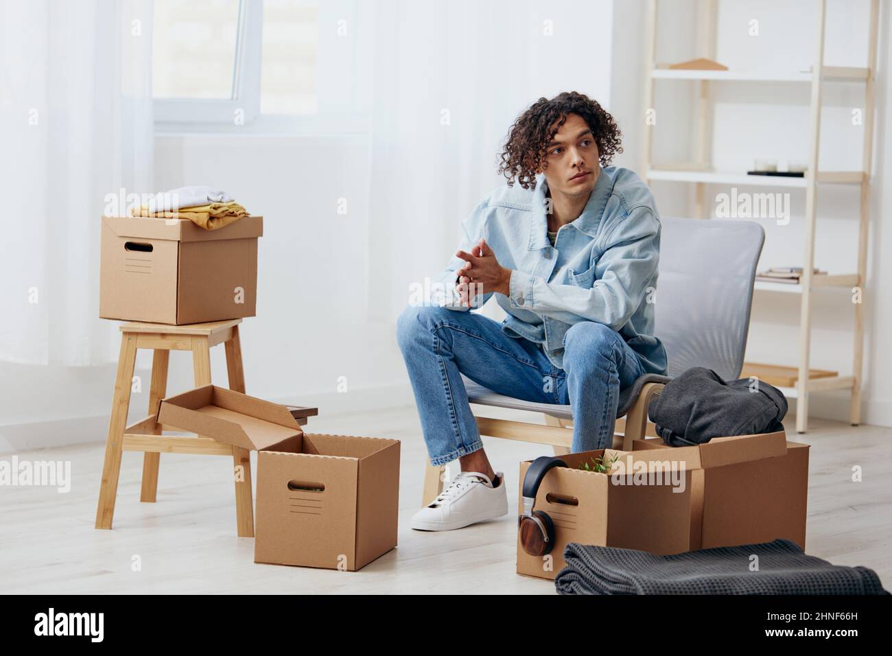A young man unpacking things from boxes in the room interior Stock ...