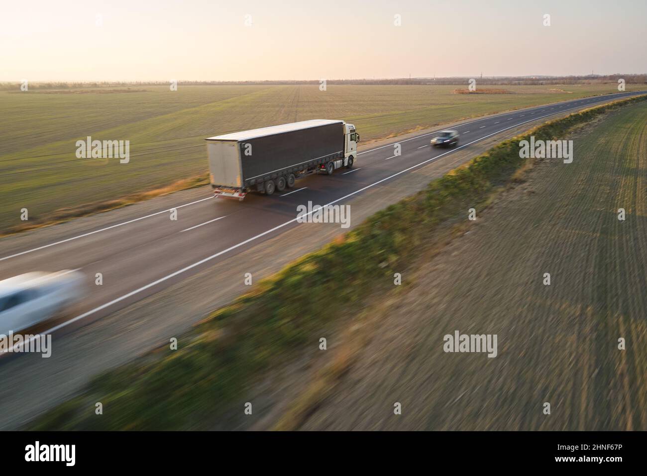 Aerial view of blurred fast moving semi-truck with cargo trailer ...