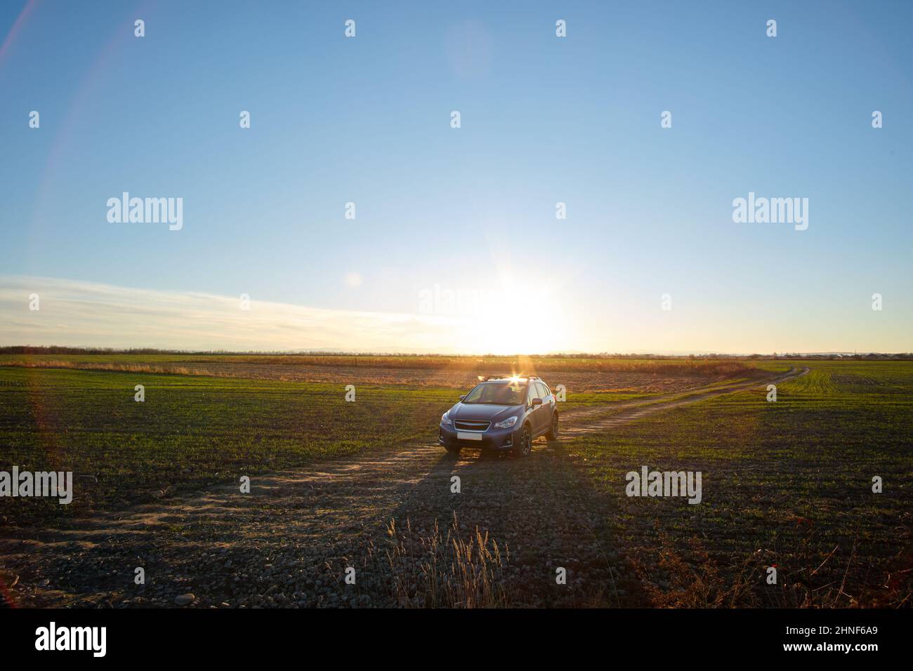 Aerial view of car driving on dirt road at sunset. Traveling by vehicle ...