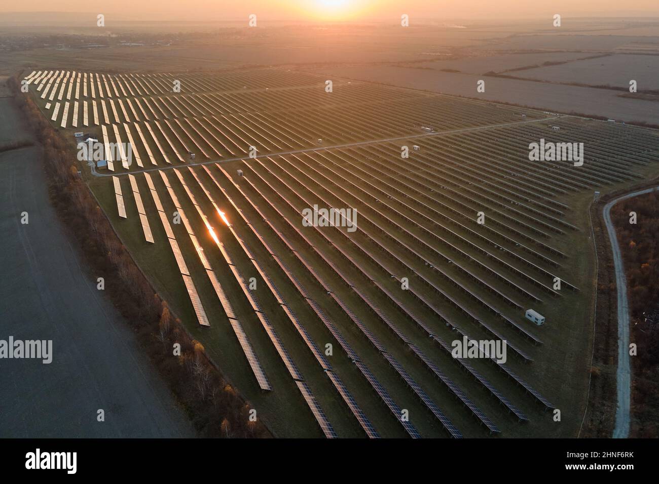 Aerial view of large sustainable electrical power plant with rows of solar photovoltaic panels ...