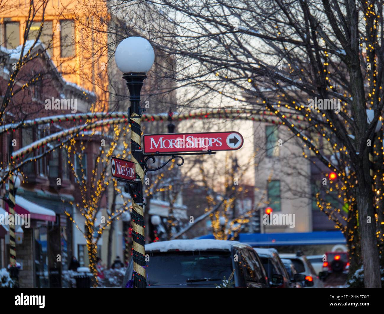 Lamp post with more shops sign on a winter evening, Downtown Oak Park ...