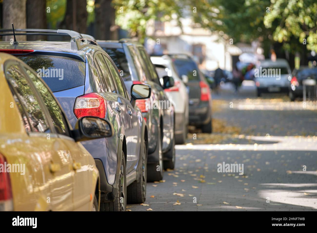 City traffic with many cars parked in line on street side Stock Photo ...