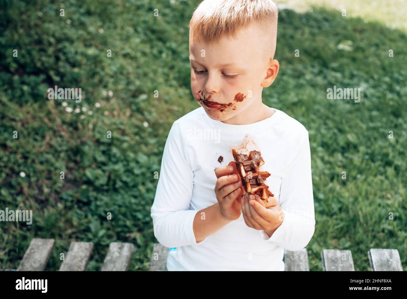 The child eating a Belgian waffle with a chocolate topping.top view ...