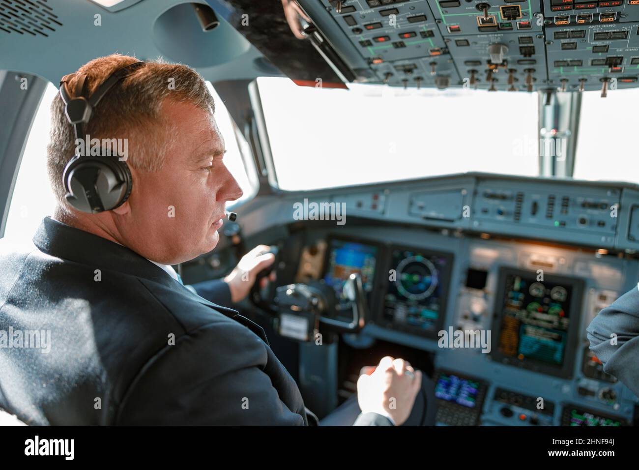 Male pilot sitting in cockpit of passenger airplane Stock Photo - Alamy