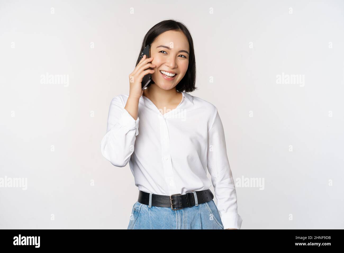 Friendly smiling asian woman talking on phone, girl on call, holding ...