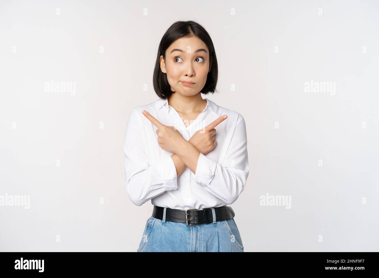 Indecisive asian woman pointing fingers sideways, pointing fingers and ...