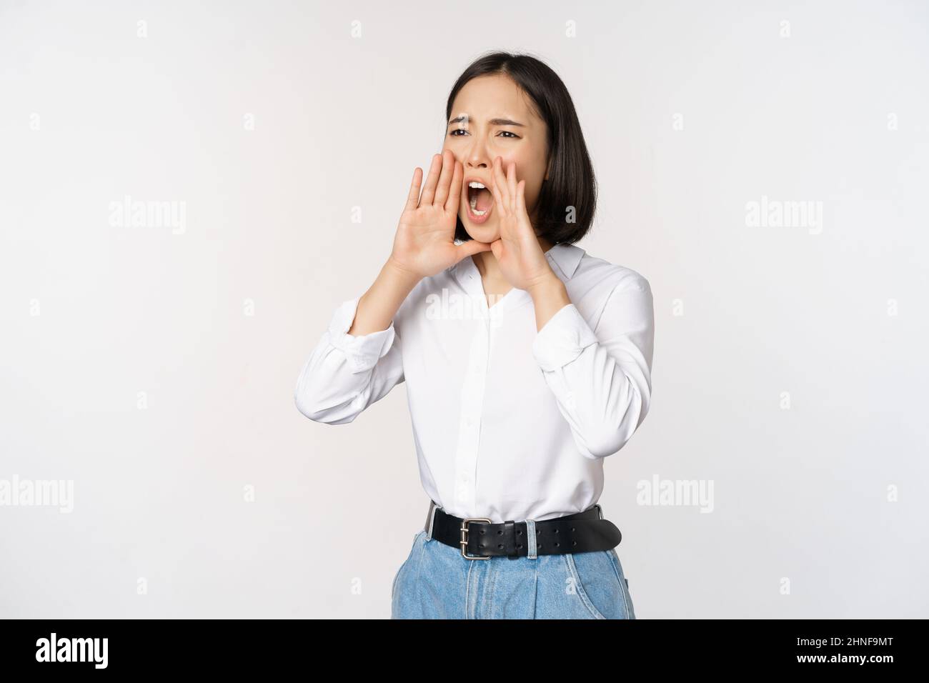 Image of young asian woman calling for someone, shouting loud and ...