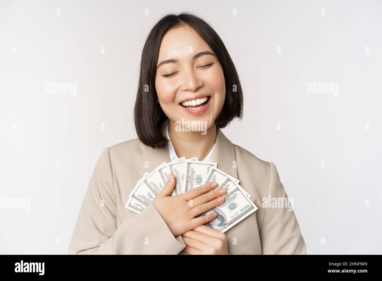 Happy asian businesswoman holding cash, hugging dollars money and ...