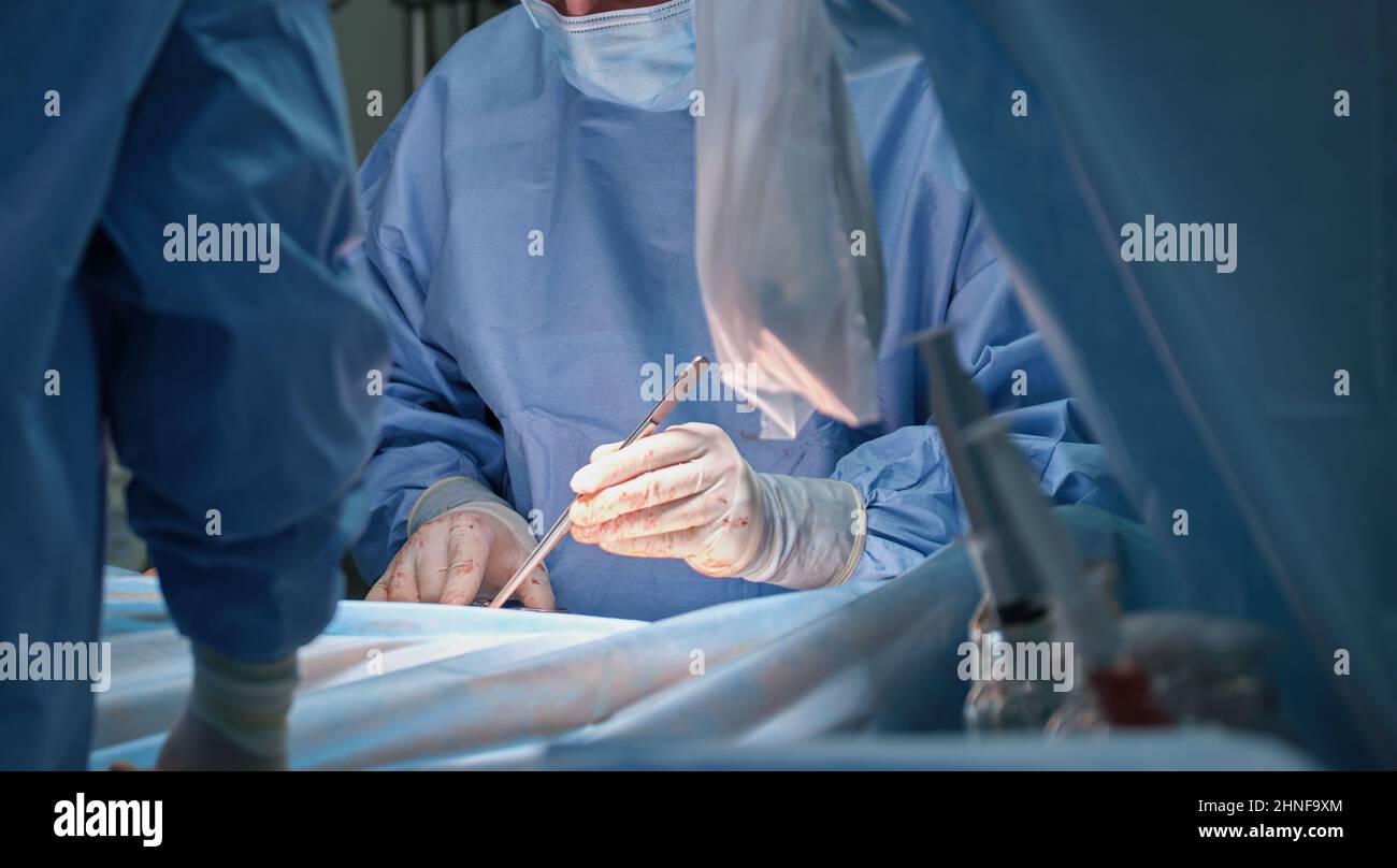 Team of professional doctors operating a patient conducting open cut ...