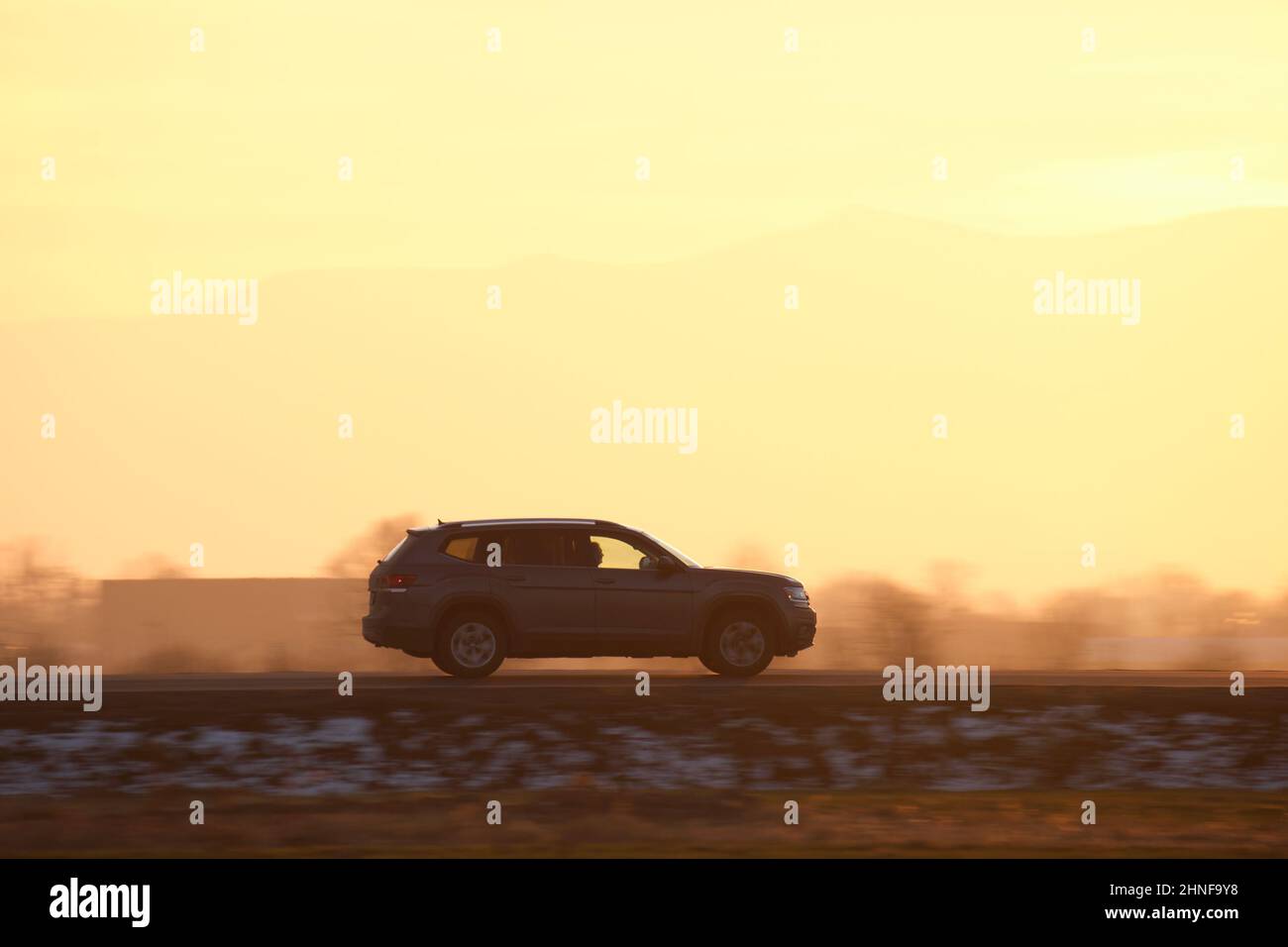 SUV car driving fast on intercity road at sunset. Highway traffic in ...