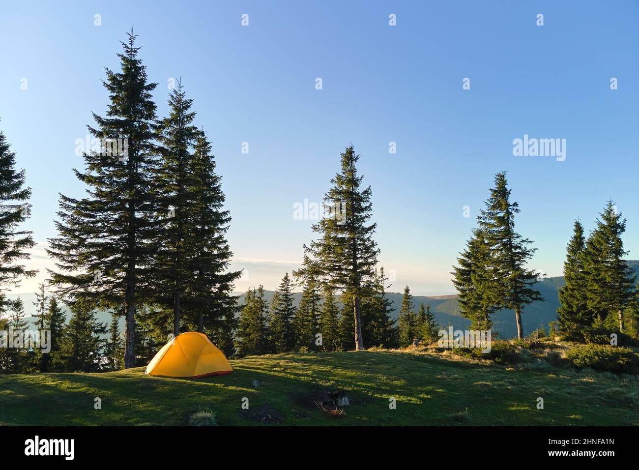 Tourist camping tent on mountain campsite at bright sunny evening ...