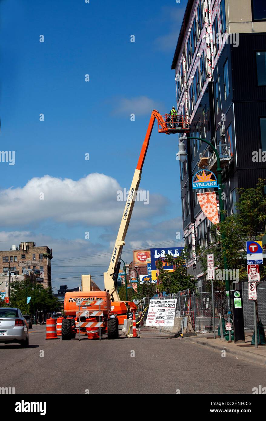 Construction work using a cherry picker to install apartment windows ...