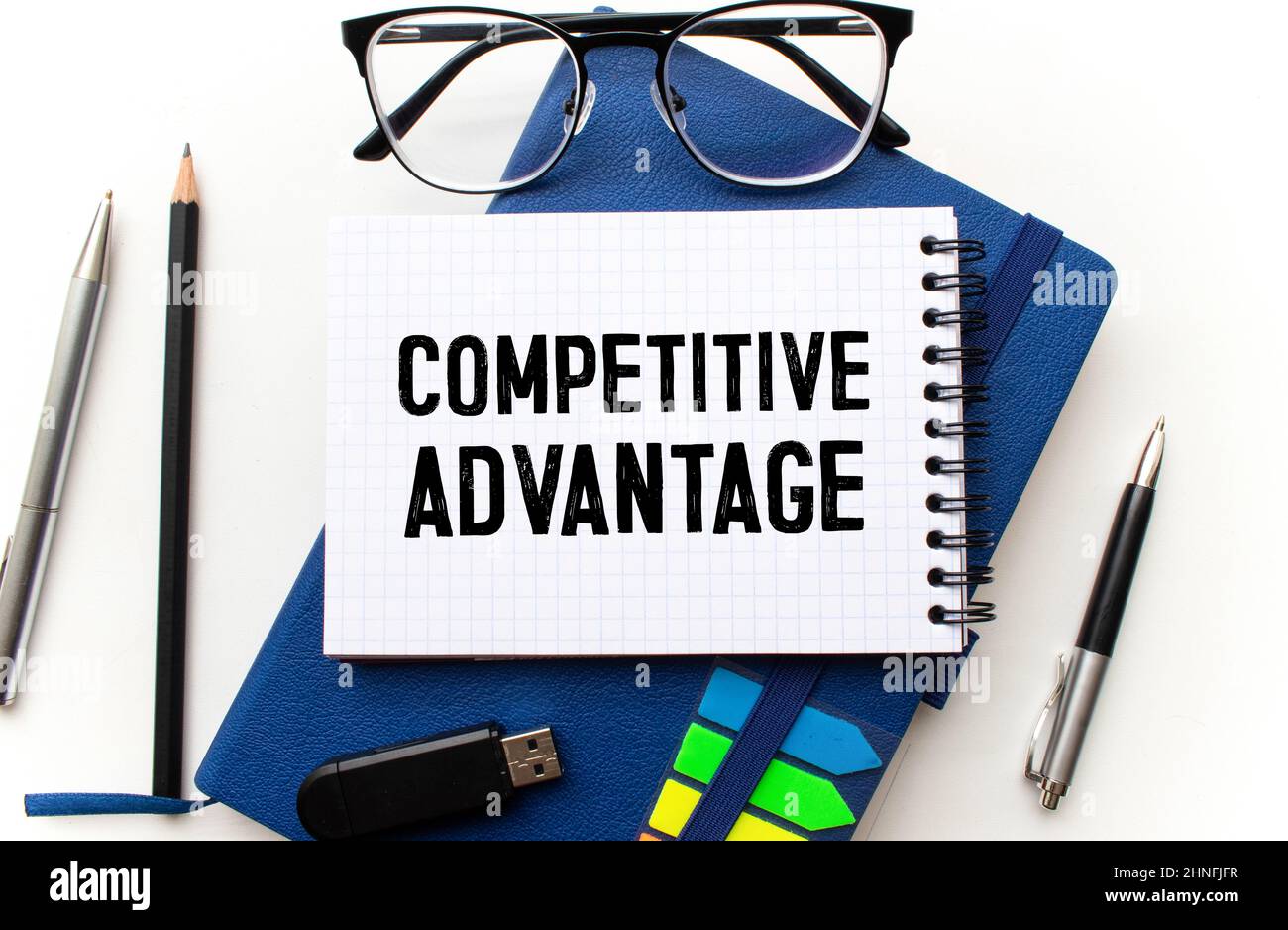 Closeup on businessman holding a card with text COMPETITIVE ADVANTAGE ...